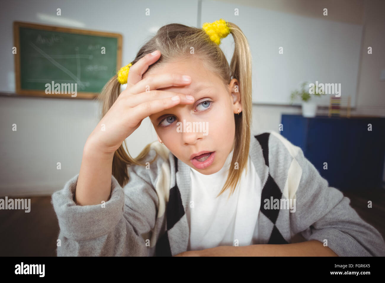 Thoughtful pupil sitting at her desk in a classroom Stock Photo - Alamy
