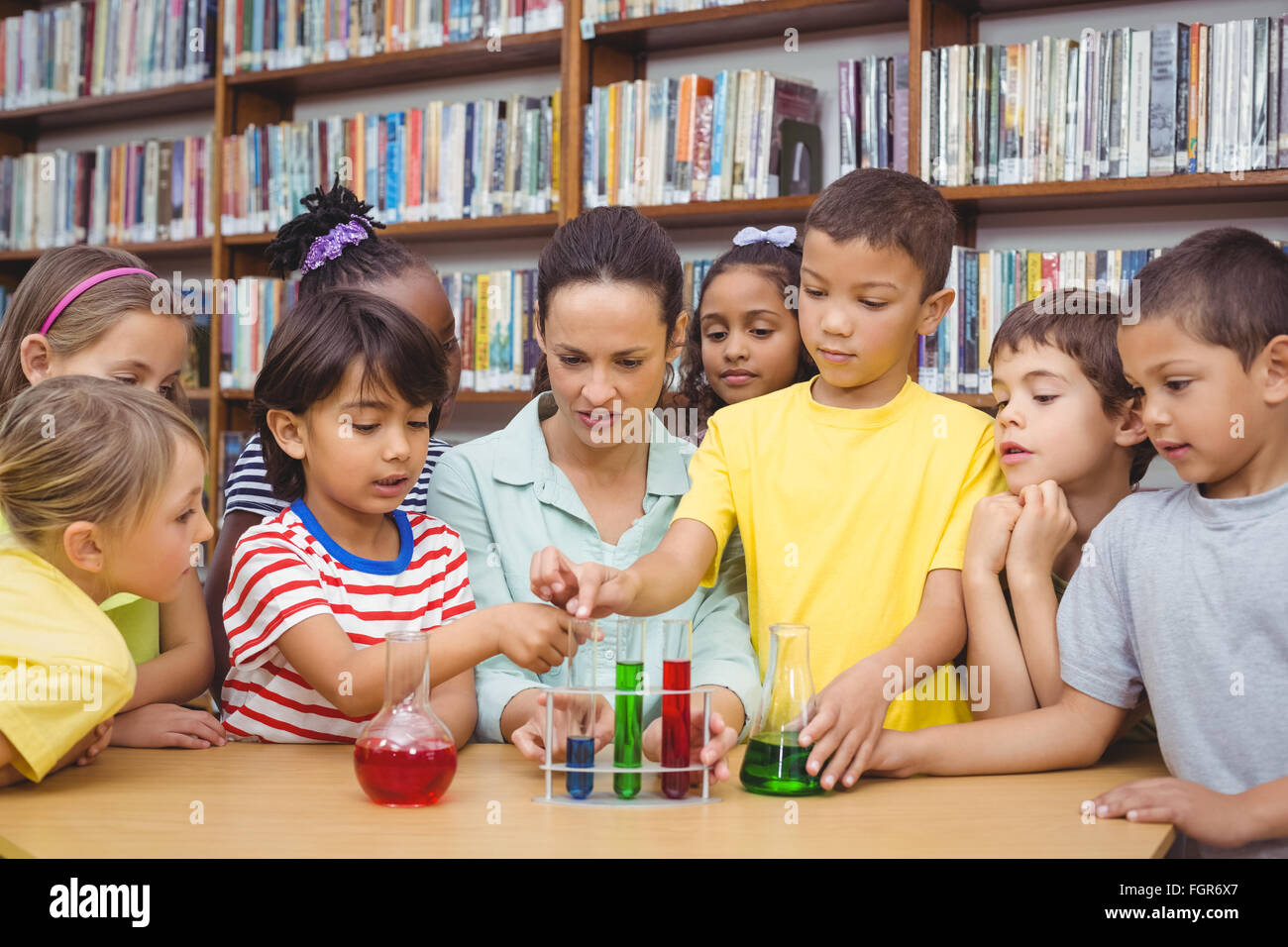 Pupils and teacher doing science in library Stock Photo - Alamy
