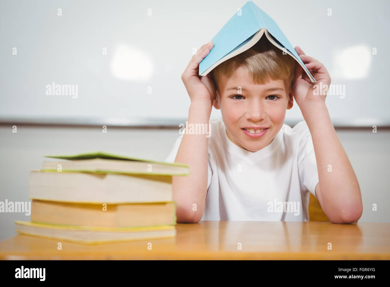 Student holding book over their head Stock Photo - Alamy