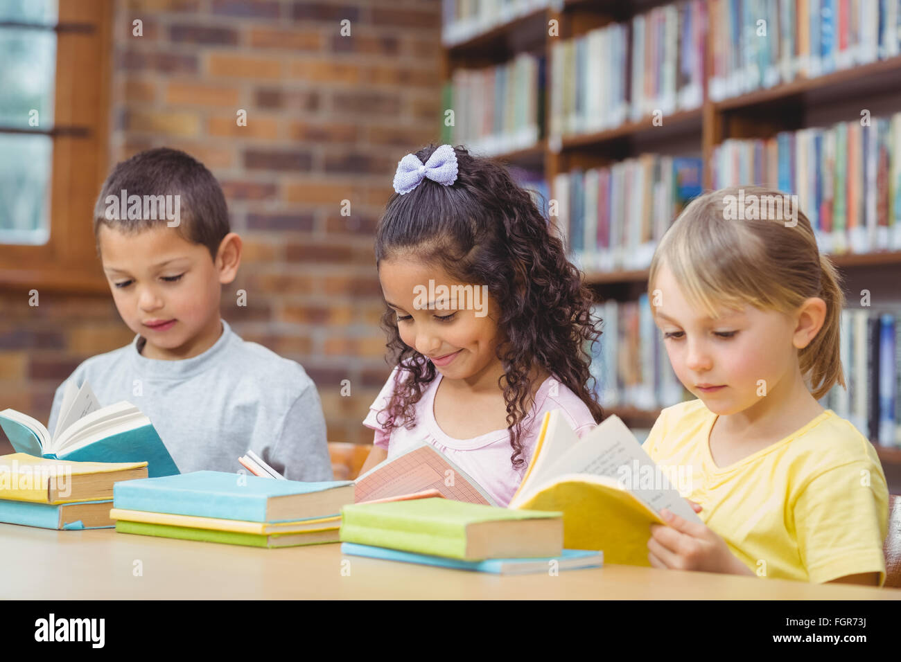Cute pupils reading books desk hi-res stock photography and images - Alamy