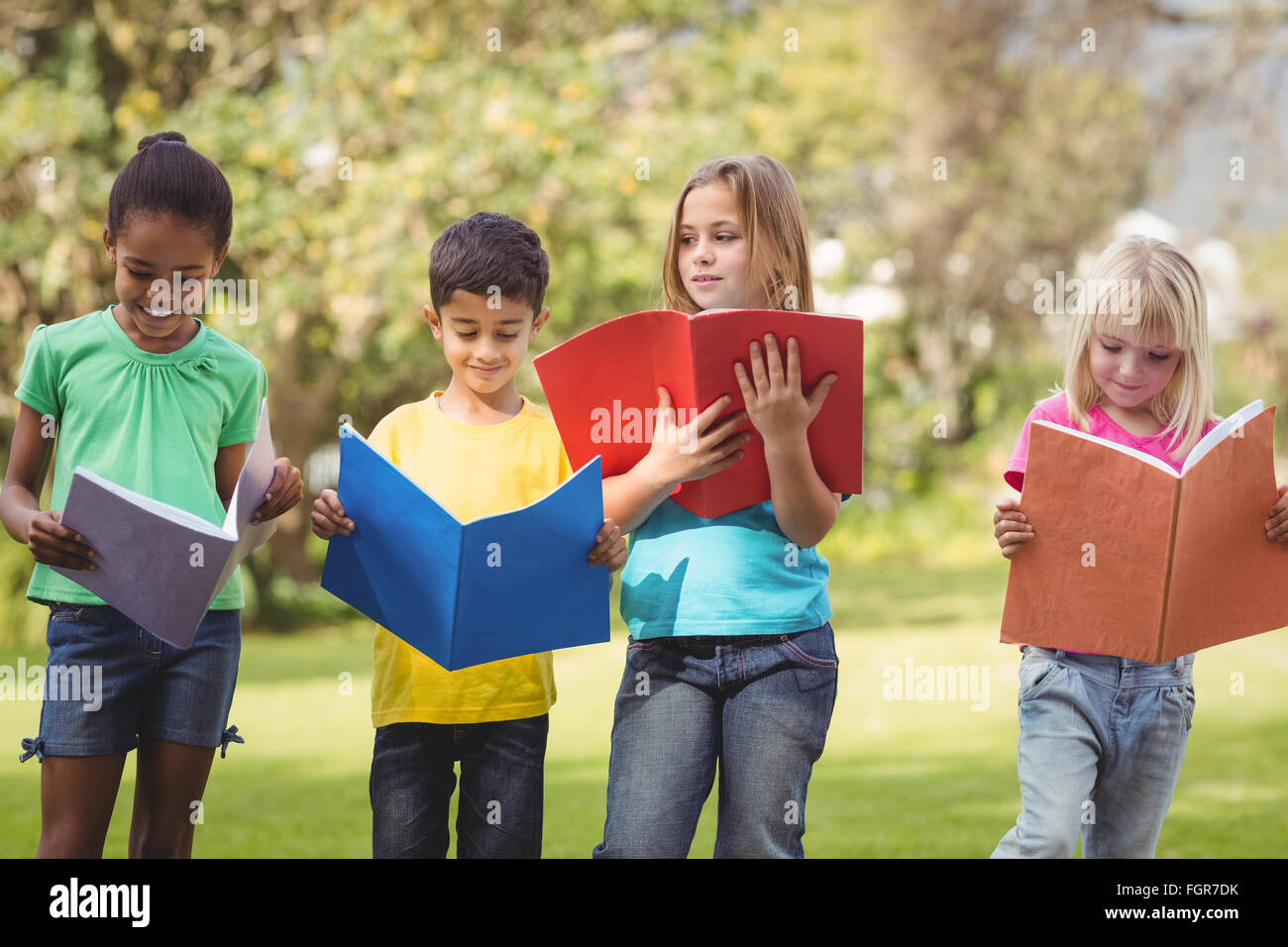 Smiling classmates reading in notepads Stock Photo - Alamy
