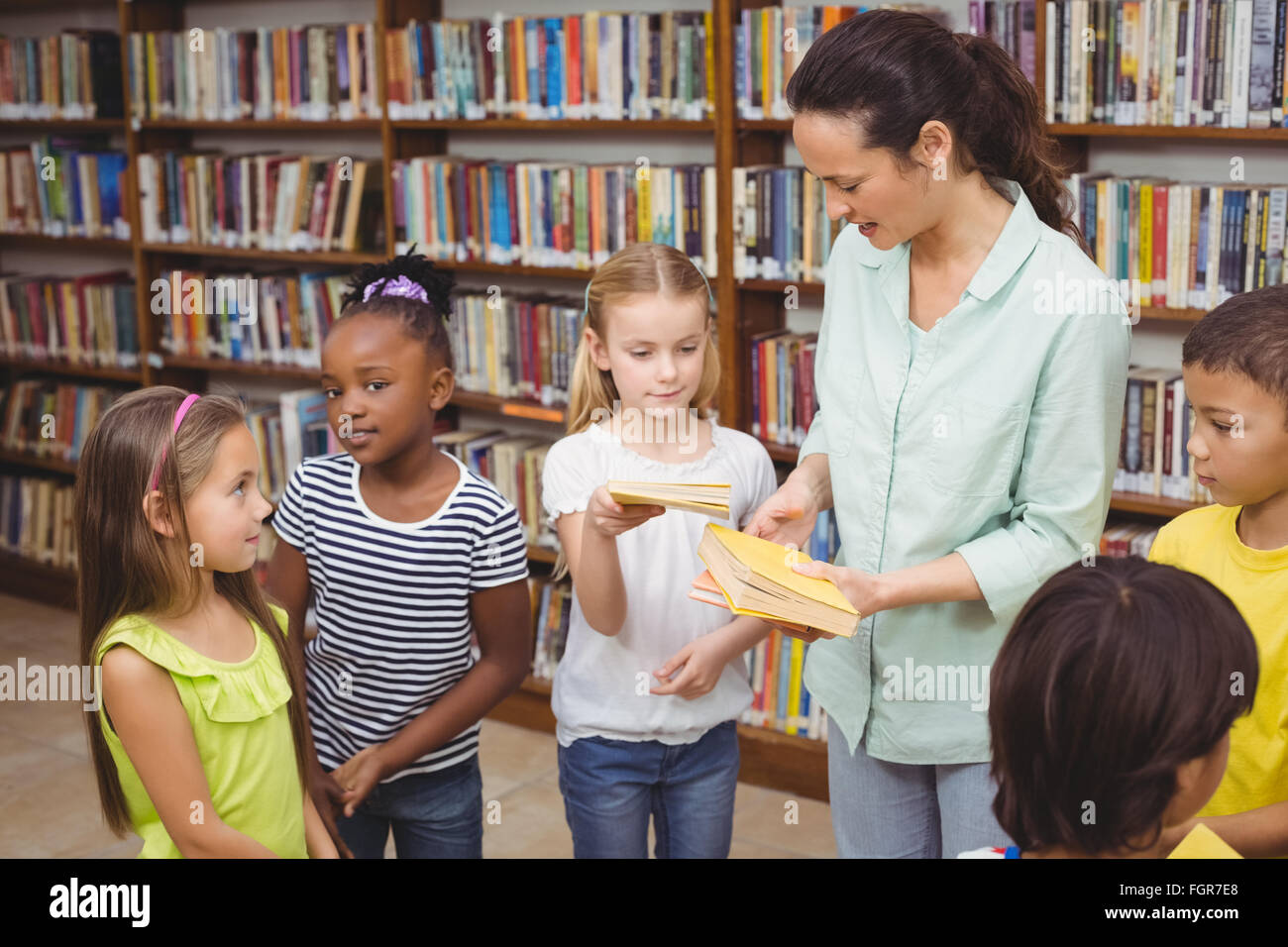 Pupils and teacher in the library Stock Photo - Alamy