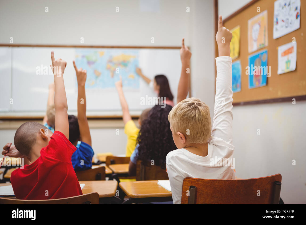 Students raising hands to answer a question Stock Photo - Alamy
