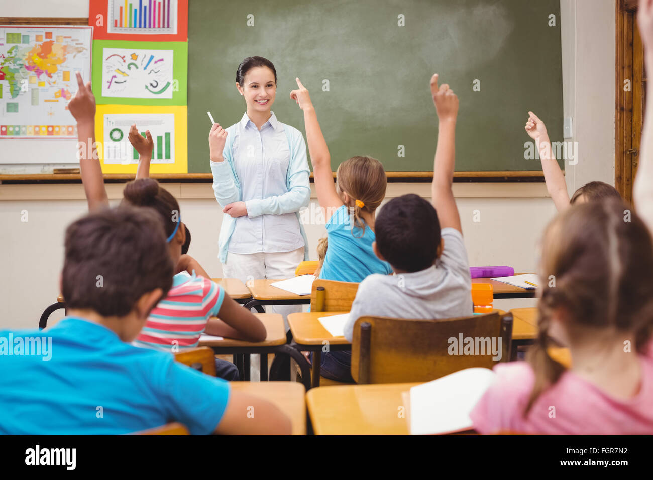 Teacher asking a question to her class Stock Photo - Alamy