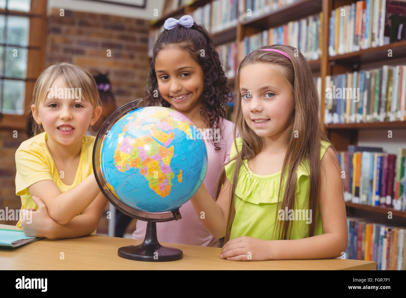Pupils in library with globe Stock Photo - Alamy