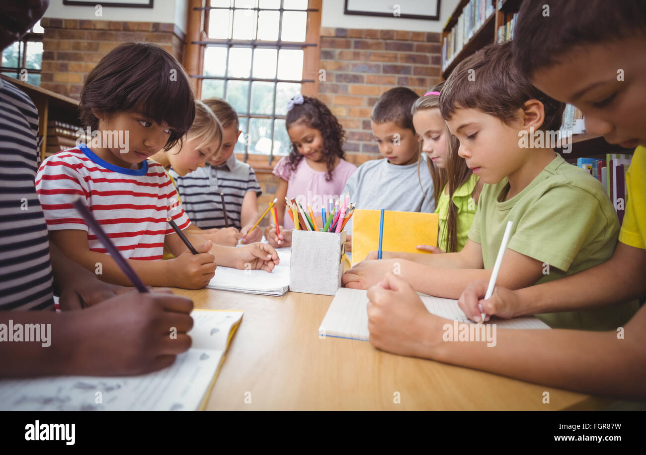 Pupils working together at desk in library Stock Photo - Alamy