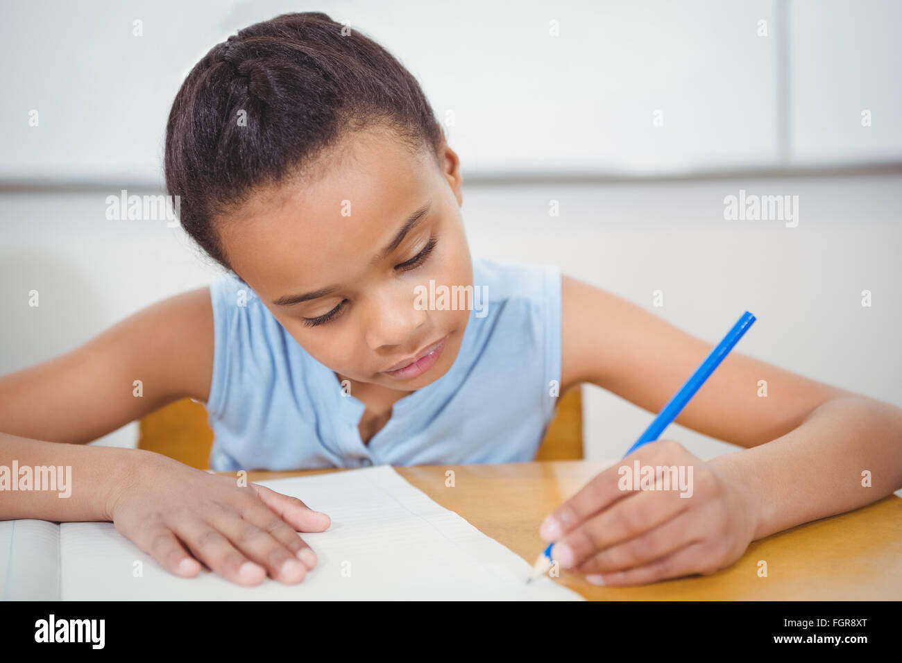 Pupil writing into a notebook Stock Photo - Alamy