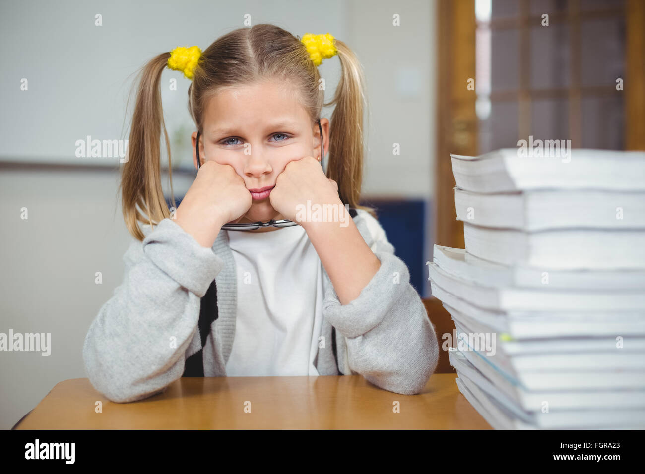 Sad pupil sitting at her desk in a classroom Stock Photo - Alamy