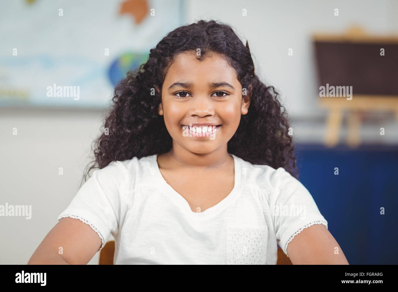 Smiling pupil sitting in a classroom Stock Photo - Alamy