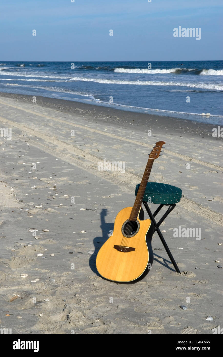 Guitar leaning against stool on Myrtle Beach seashore South Carolina ...