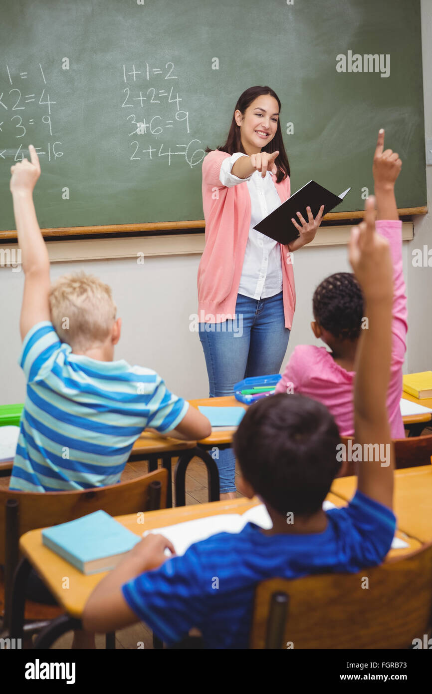 Teacher pointing boy raised hand hi-res stock photography and images ...