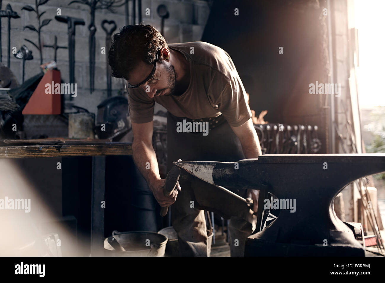 Blacksmith working at anvil in forge Stock Photo - Alamy