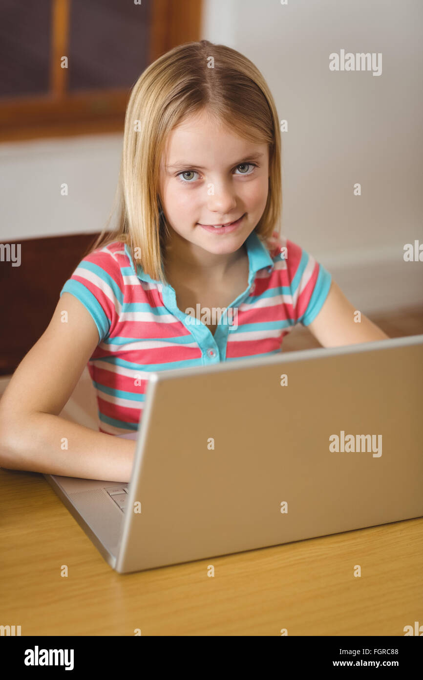 Cute pupil in class using laptop Stock Photo - Alamy