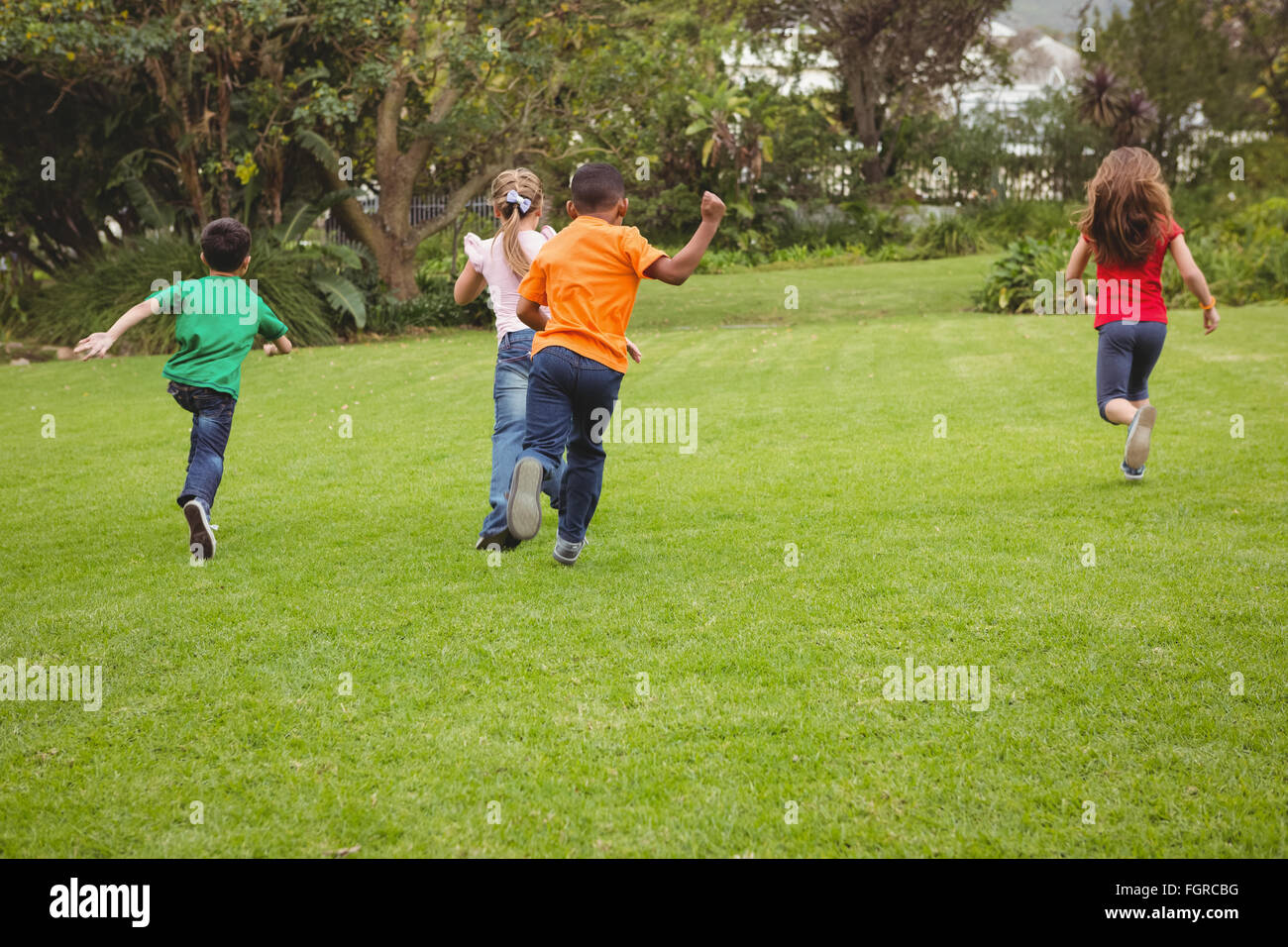 Happy kids running across the grass Stock Photo - Alamy