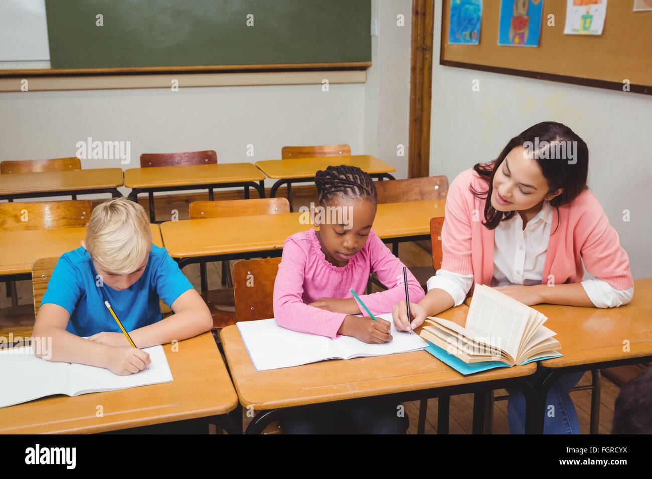 Teacher sitting with her students Stock Photo - Alamy