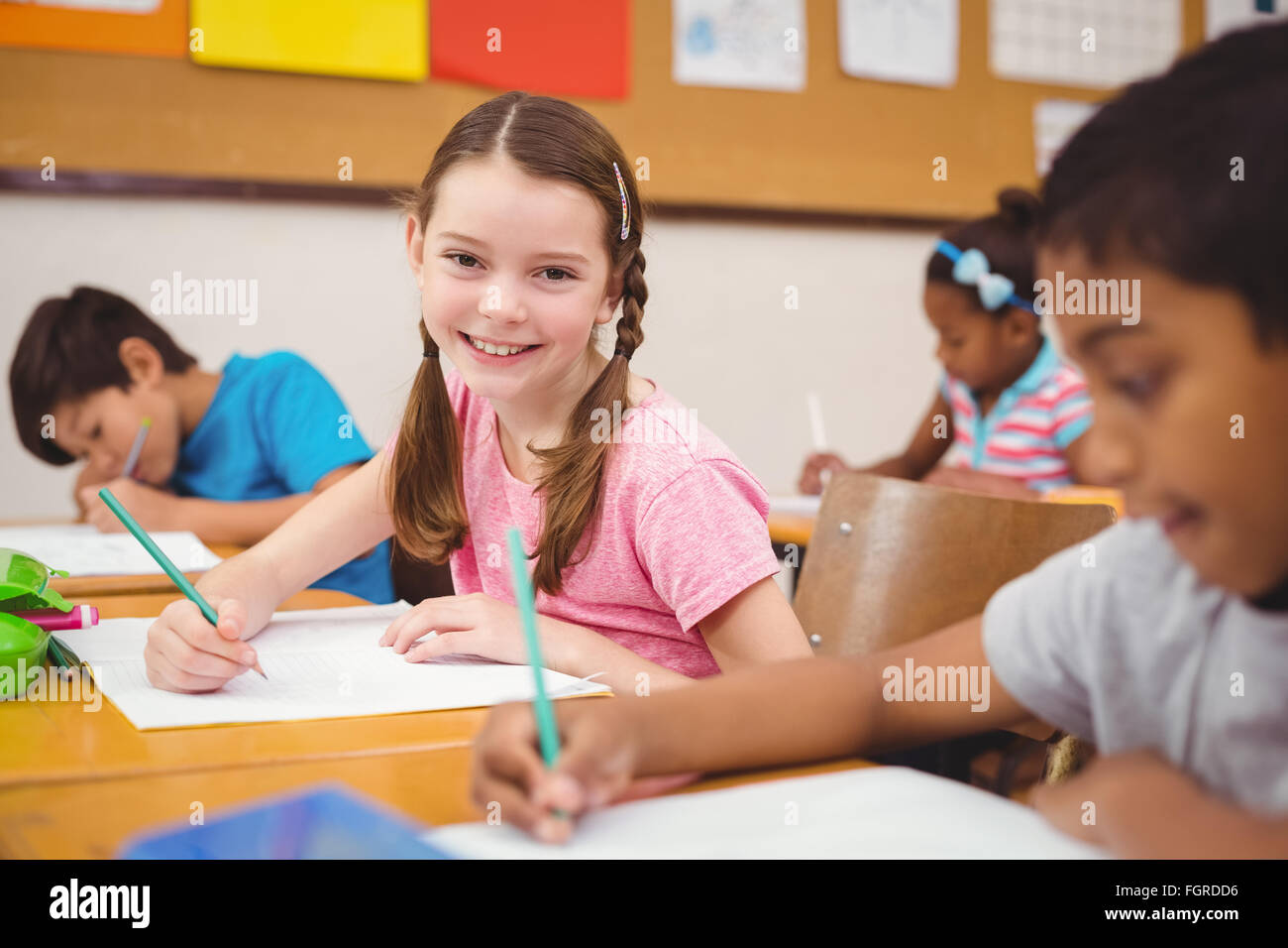 Pupil working at her desk Stock Photo - Alamy