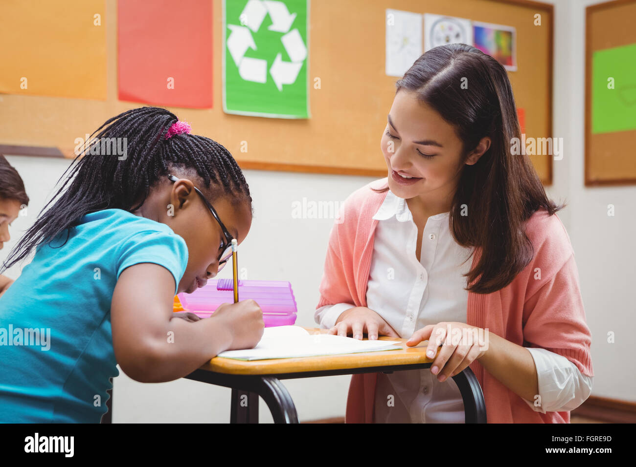 Happy teacher helping her students Stock Photo - Alamy