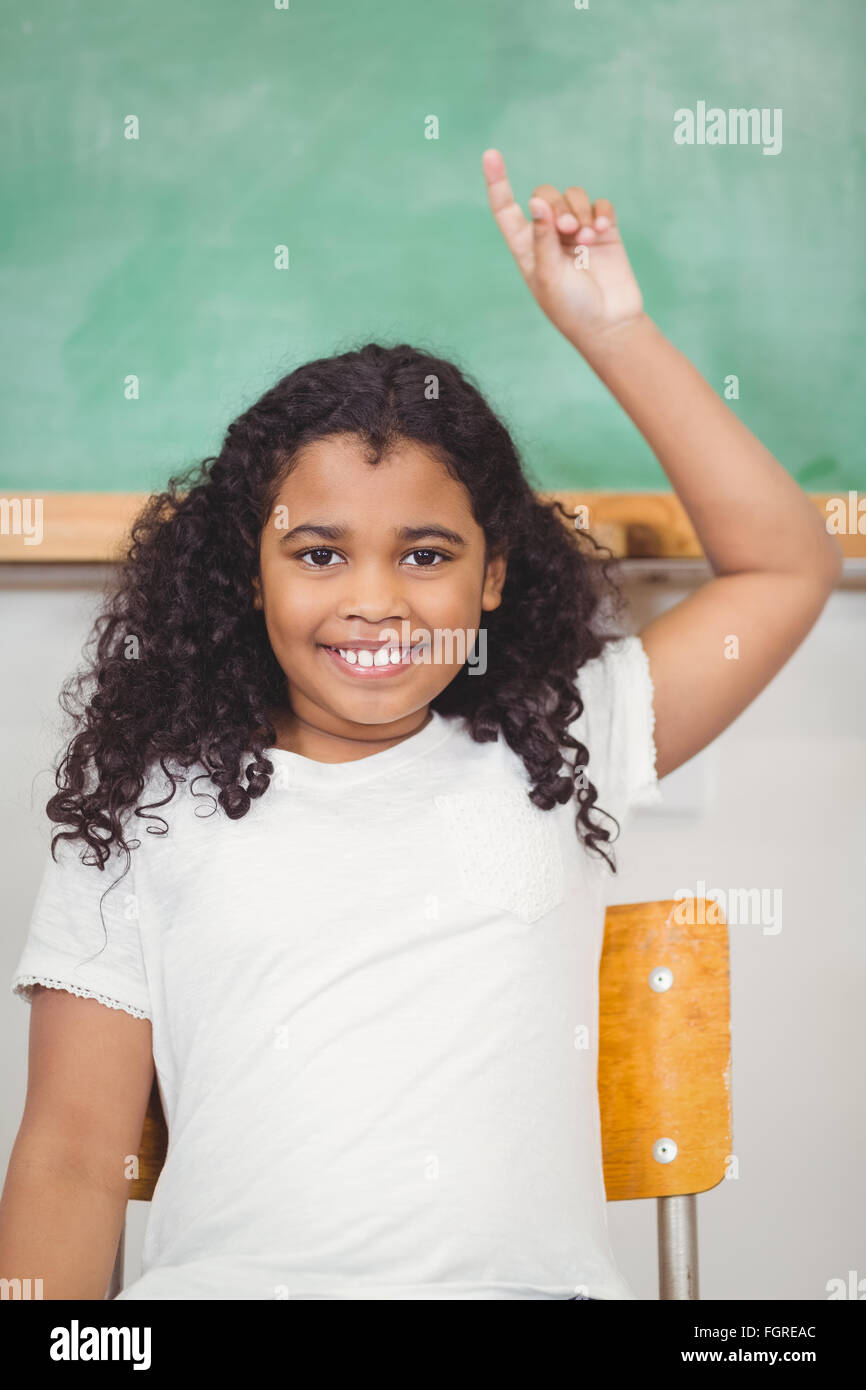 Cute pupil raising hand in a classroom Stock Photo - Alamy