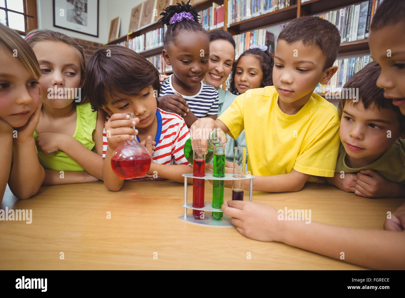 Pupils and teacher doing science in library Stock Photo - Alamy