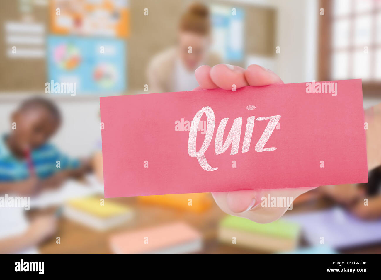 Quiz against pretty teacher helping pupils in classroom Stock Photo - Alamy