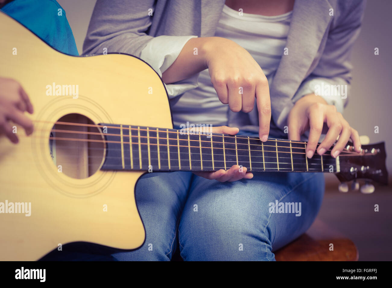 Teacher giving guitar lessons to pupil Stock Photo - Alamy