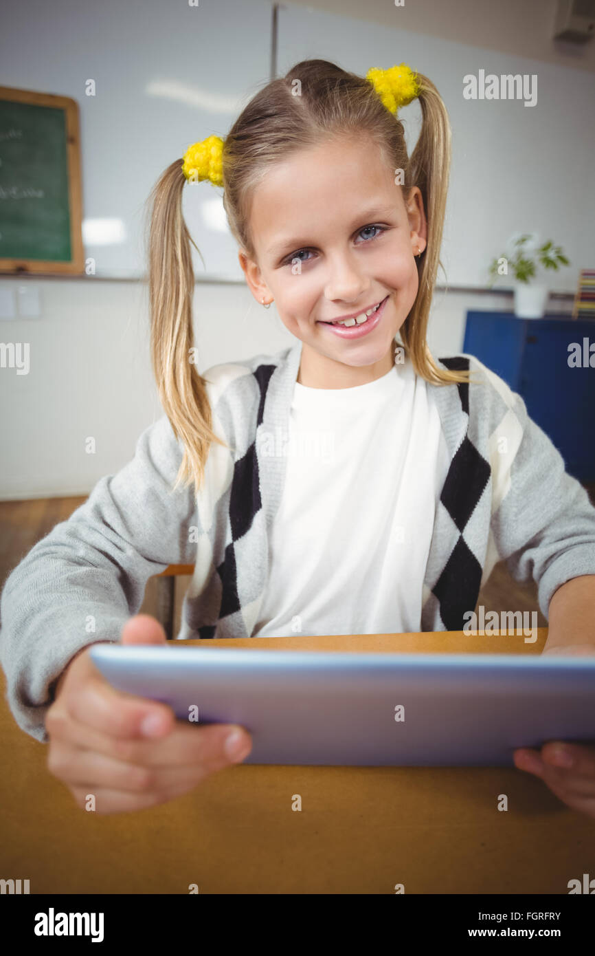 Smiling pupil using tablet at her desk in a classroom Stock Photo - Alamy