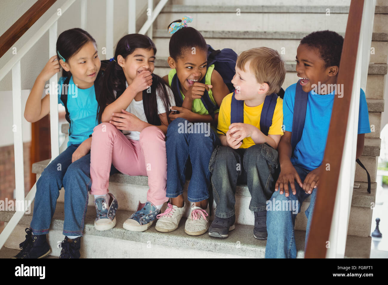 Happy pupils laughing and sitting on stairs Stock Photo - Alamy