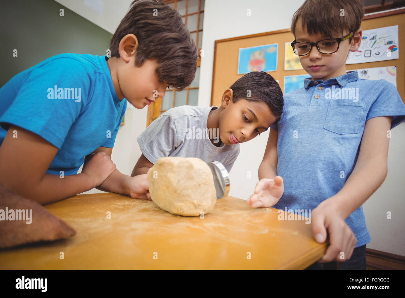 Pupils looking at rock with magnifying glass Stock Photo - Alamy