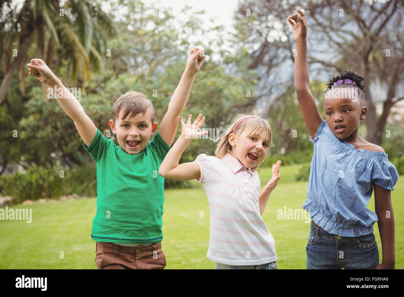 Kids celebrating with arms raised Stock Photo - Alamy