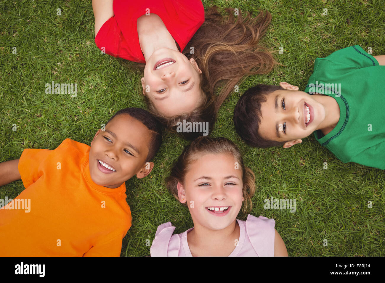 Smiling pupils lying on the ground Stock Photo - Alamy
