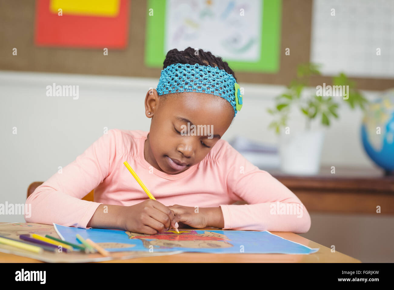 Focused pupil colouring a picture at her desk Stock Photo - Alamy
