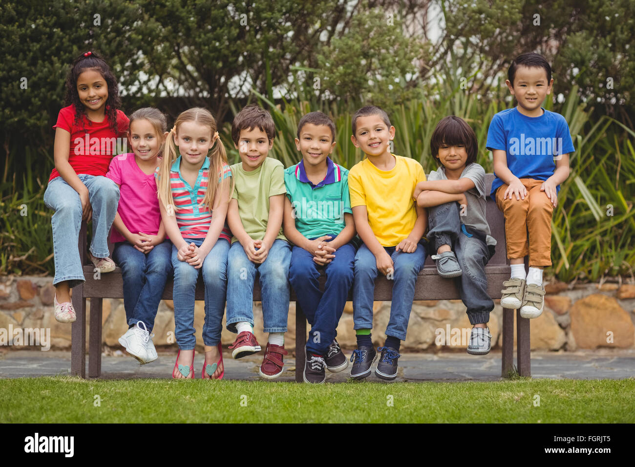 Cute pupils sitting on bench outside Stock Photo - Alamy