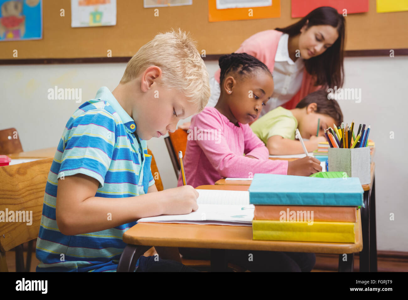 Smiling teacher helping a student Stock Photo - Alamy