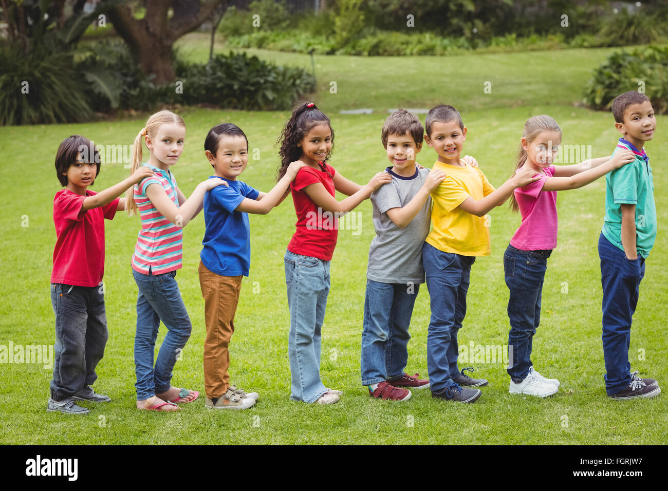 Cute pupils standing on the grass outside Stock Photo - Alamy