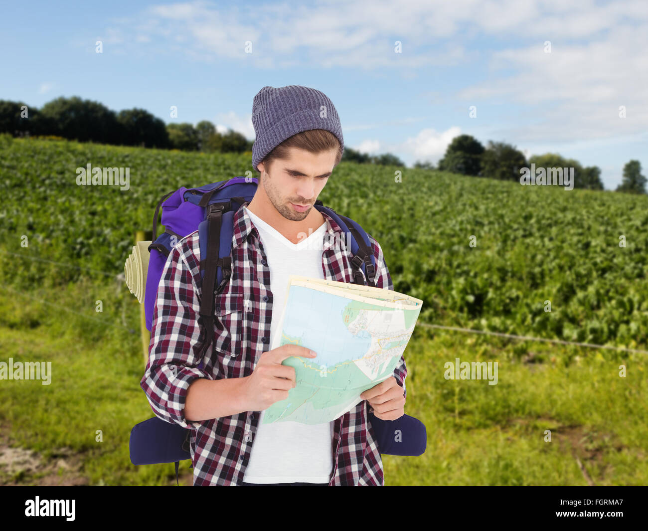 Composite image of man with luggage looking in map Stock Photo - Alamy