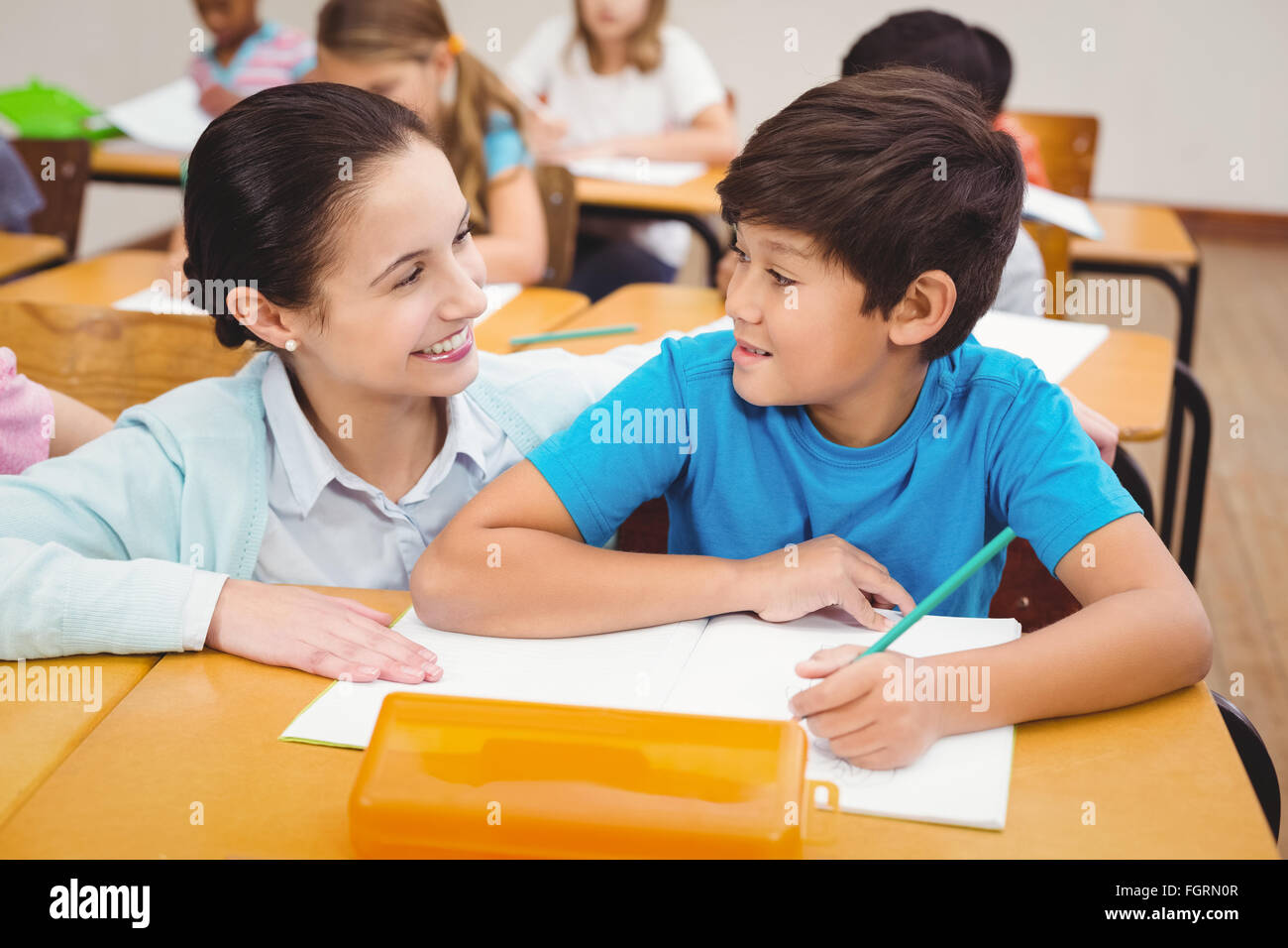 Teacher helping a little boy during class Stock Photo - Alamy