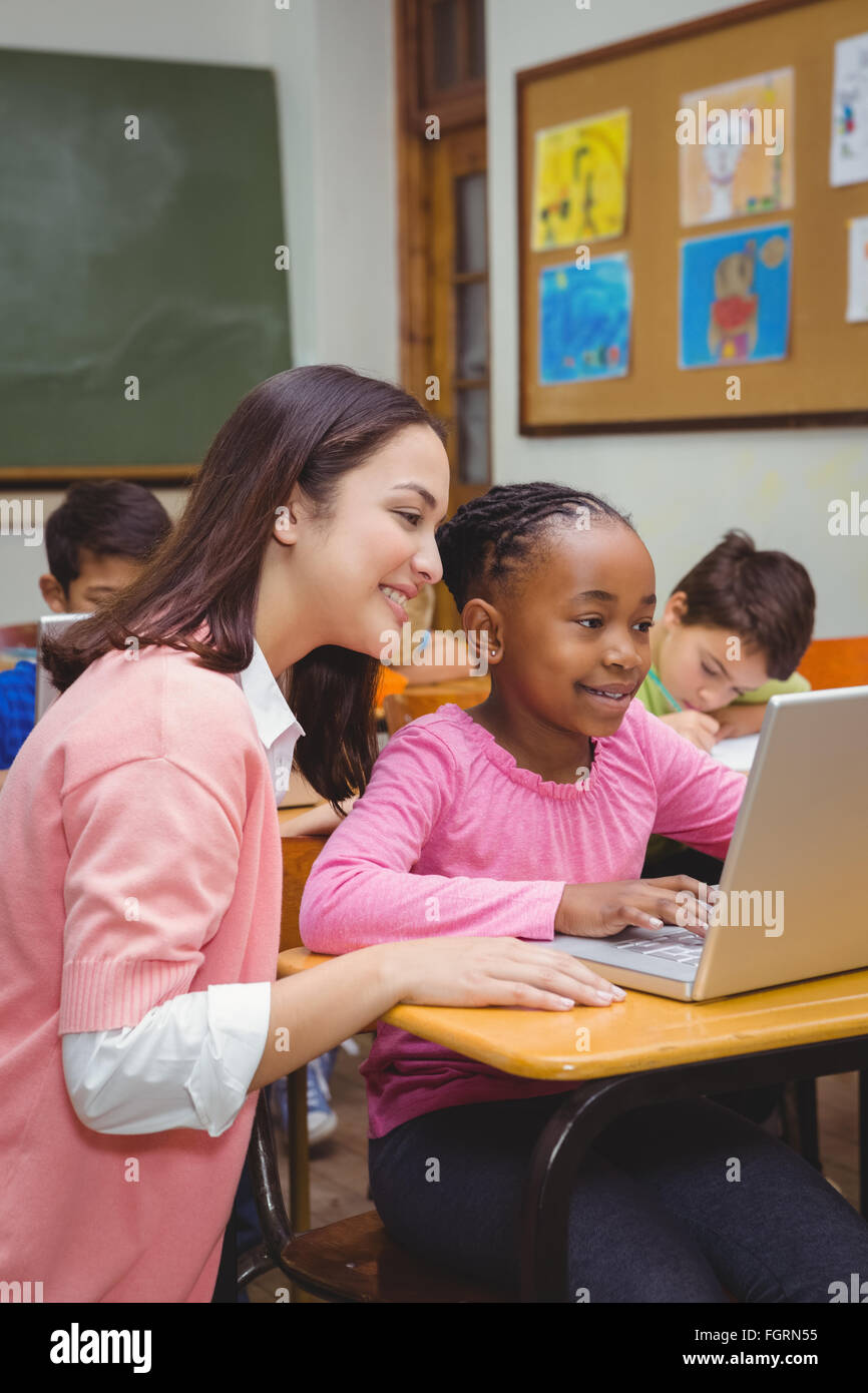 Happy teacher using laptop with student Stock Photo - Alamy