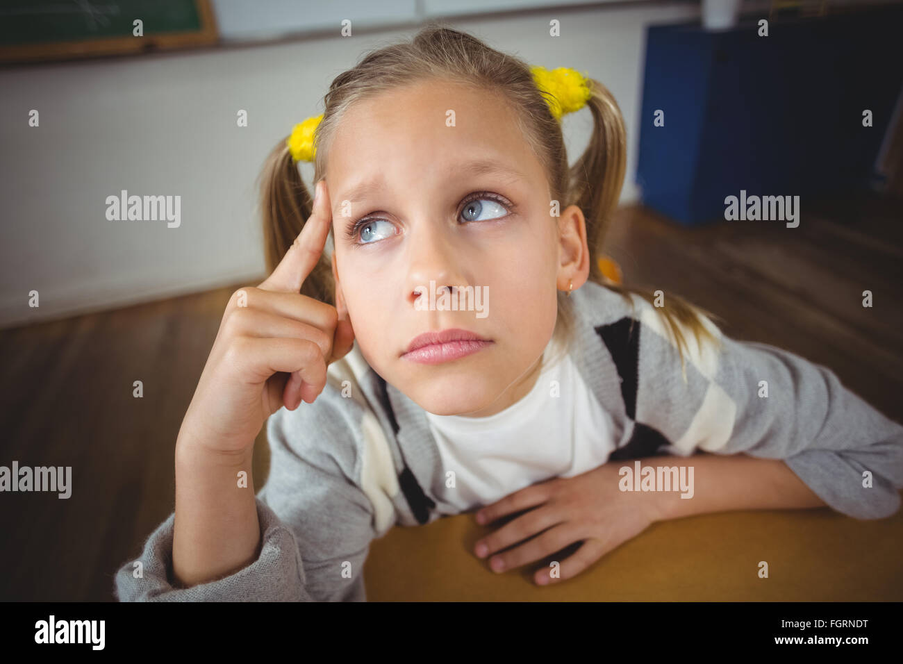 Thoughtful pupil sitting at her desk in a classroom Stock Photo - Alamy