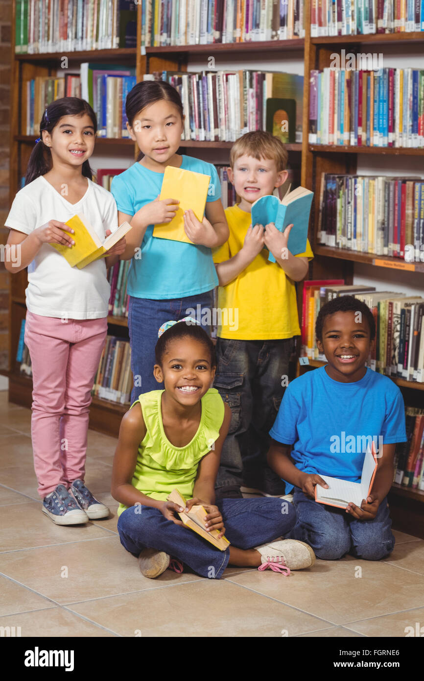 Smiling pupils with books in the library Stock Photo - Alamy