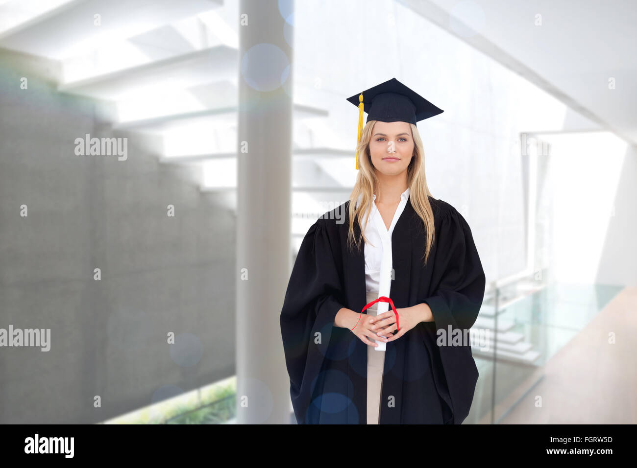 Composite image of blonde student in graduate robe holding her diploma ...