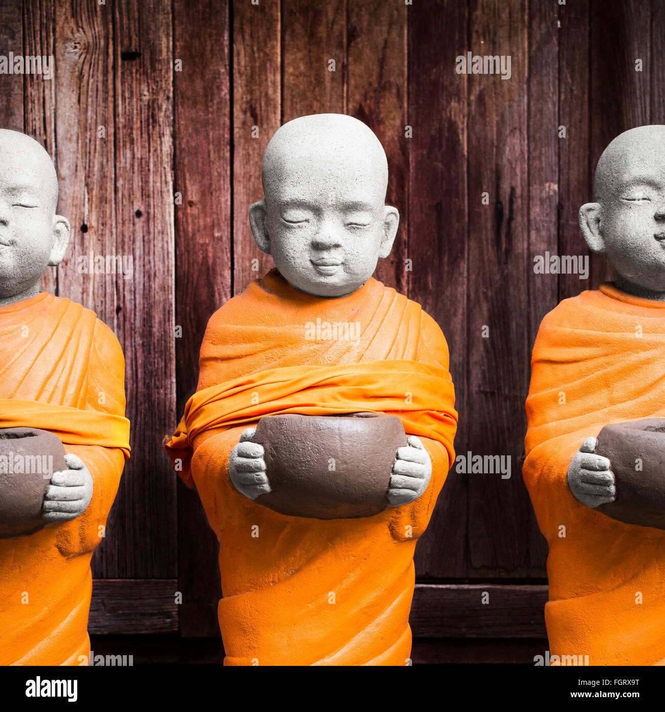 Monk statue holding bowl Stock Photo - Alamy