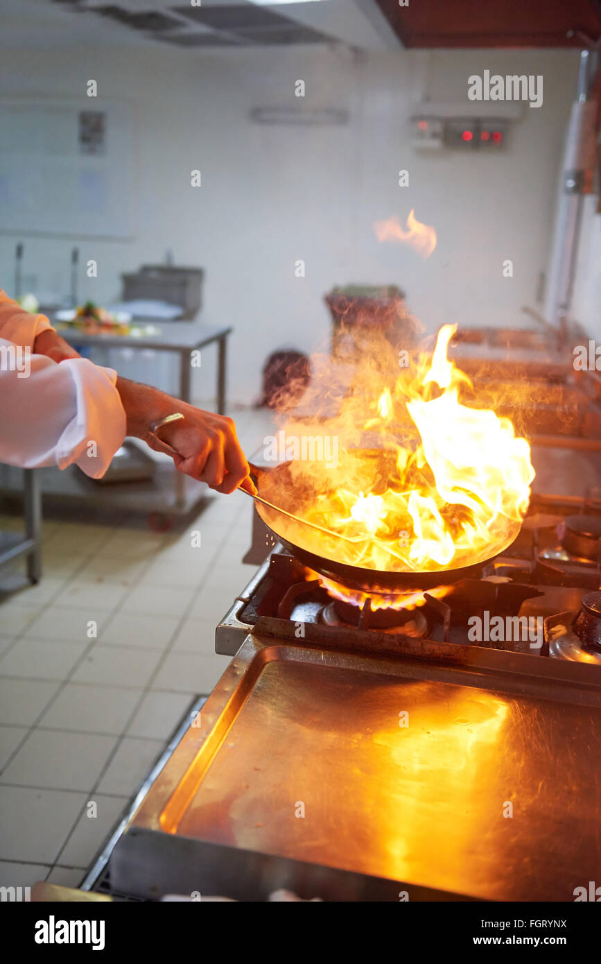 chef in hotel kitchen prepare food with fire Stock Photo - Alamy