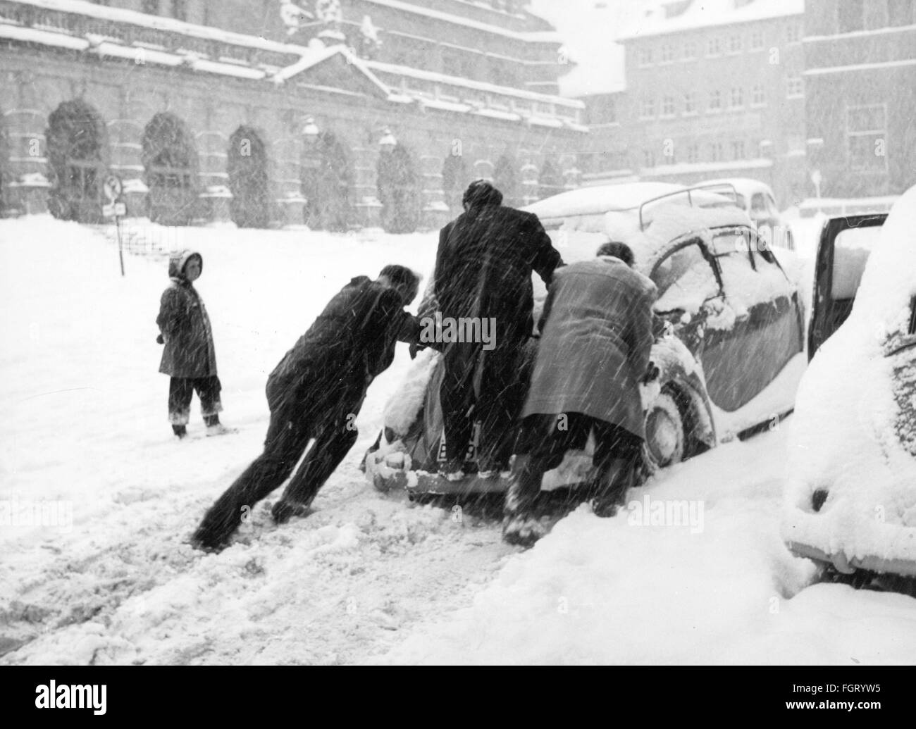 season, winter, snow covered VW beetle is push-started, 1960s ...