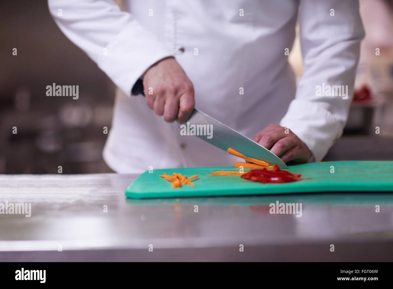 chef in hotel kitchen slice vegetables with knife Stock Photo - Alamy
