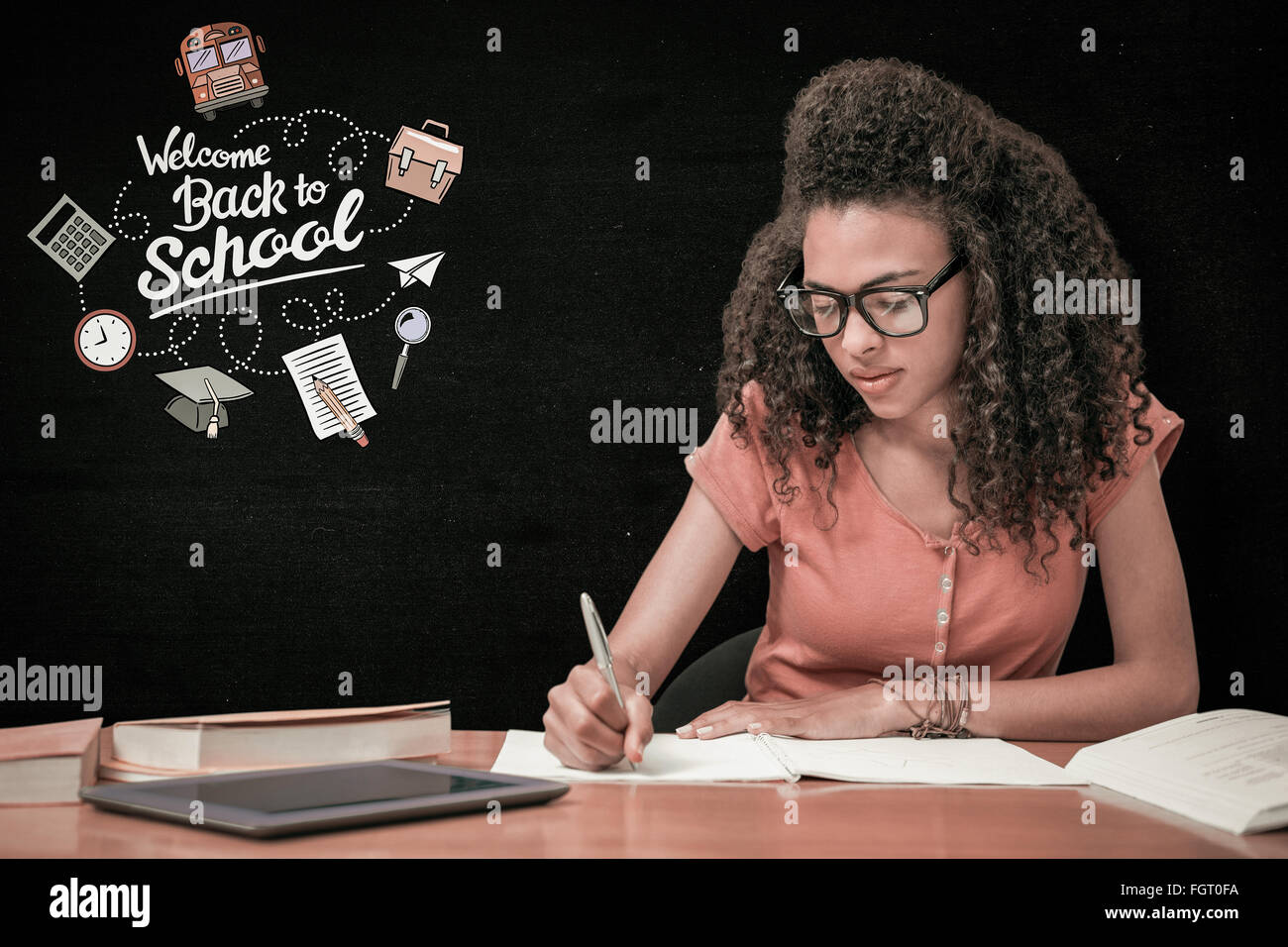 Composite image of student sitting in library writing Stock Photo - Alamy