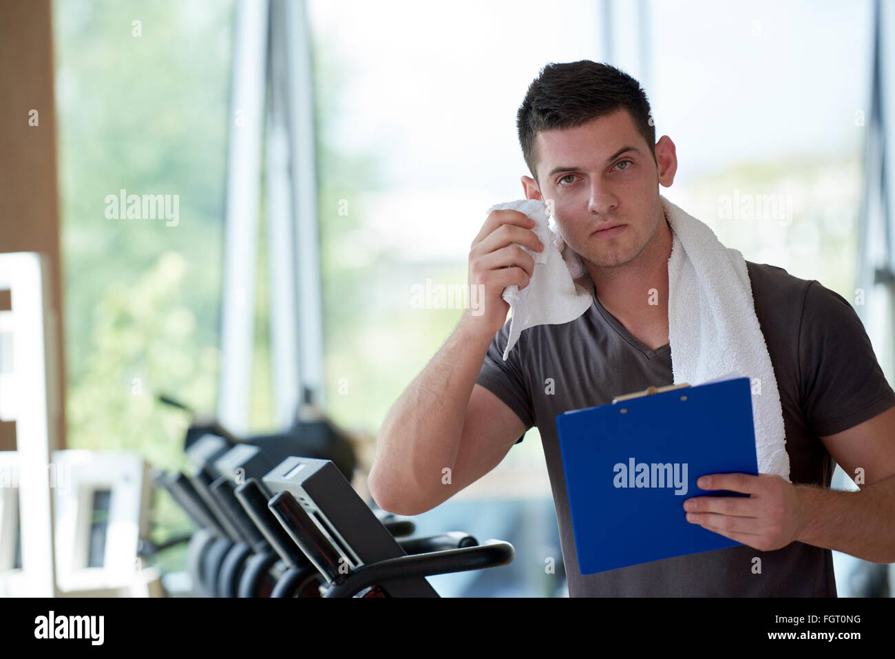 trainer with clipboard standing in a bright gym Stock Photo - Alamy