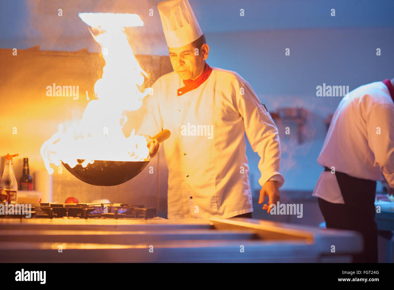 chef in hotel kitchen prepare food with fire Stock Photo - Alamy