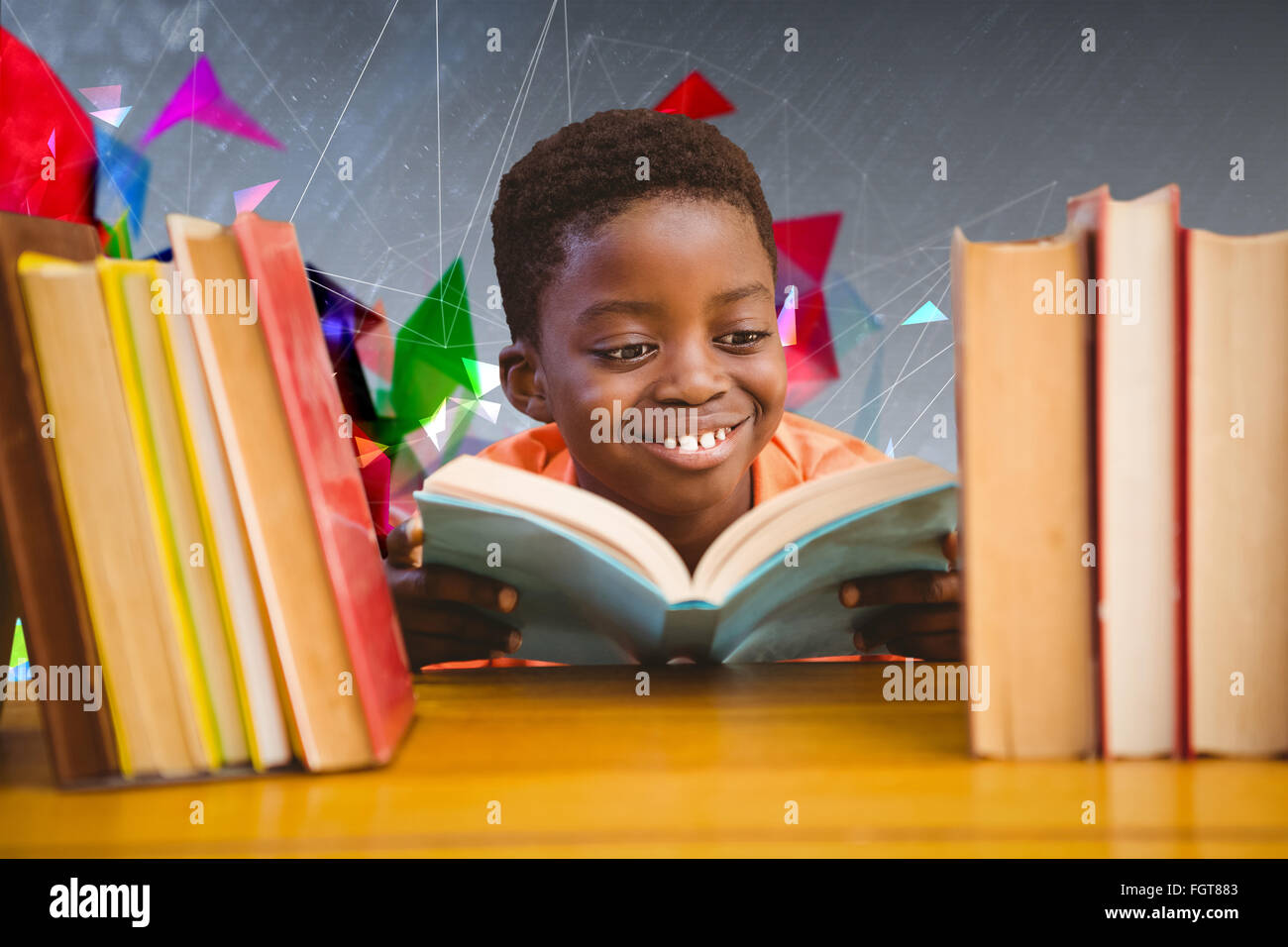 Composite image of cute boy reading book in library Stock Photo - Alamy
