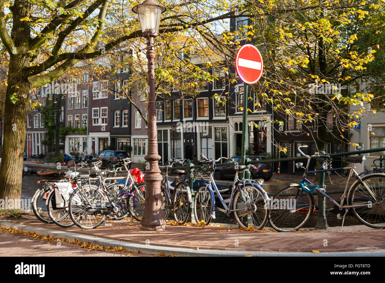 Bicycles / bikes / cycles chained to railing / railings and a bike rack ...