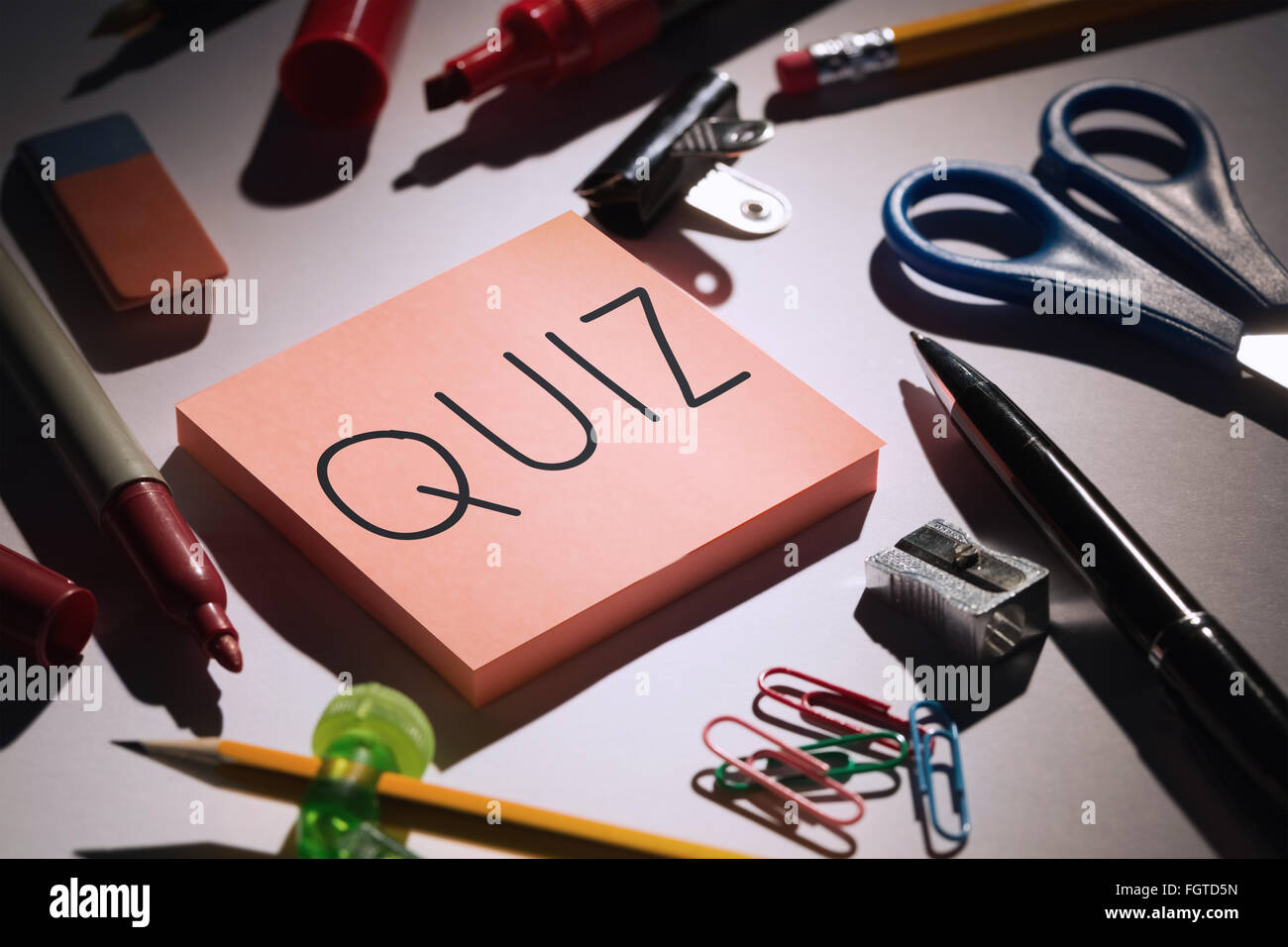 Quiz against students table with school supplies Stock Photo - Alamy